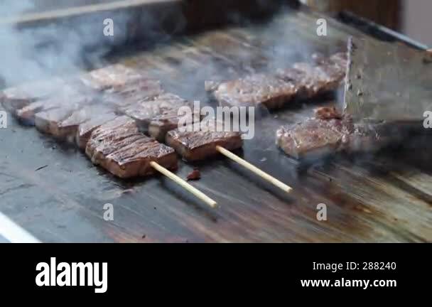Chef grilling skewered Japan Wagyu beef or meat with a fire blowtorch ...