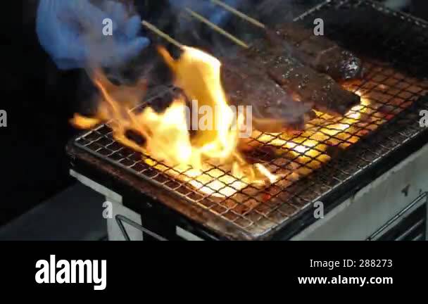 Chef grilling skewered Japan Wagyu beef or meat with a fire blowtorch ...