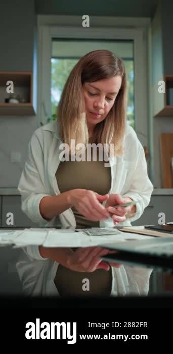 Woman calculating domestic bills and counting remaining money, sitting ...