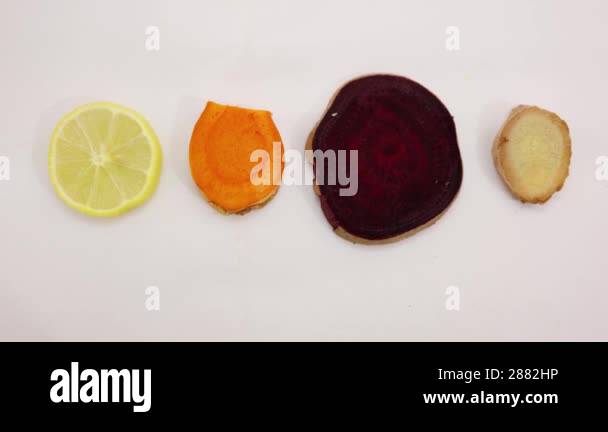 slice of fresh raw turmeric, beetroot, lemon and ginger in studio on ...