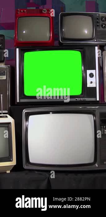 Stacked Old Television Turning On Green Screen Among Broken Vintage TVs ...