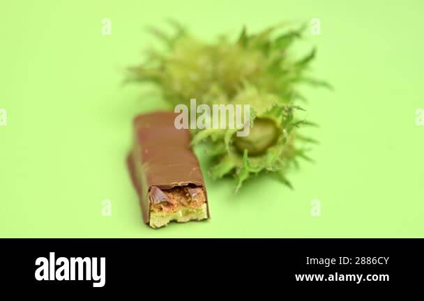 hazelnut with chocolate bar on green background Stock Video Footage - Alamy