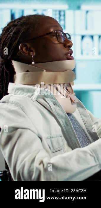 Vertical video Wheelchair user with a fractured neck injury wearing ...
