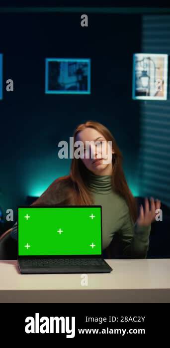 Vertical video Young entertainer presenting green screen laptop from ...