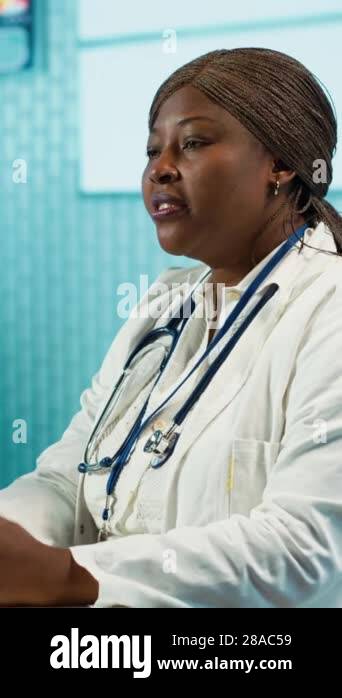 Vertical video Portrait of african american medic expert having a ...