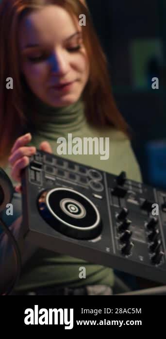 Vertical video Young artist films DJ mixing tutorial in apartment ...