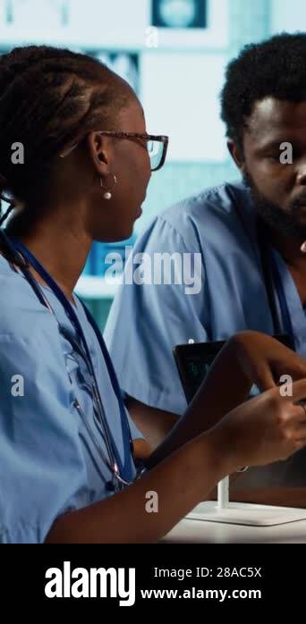 Vertical video Team of young nurses learning the practice from a doctor ...