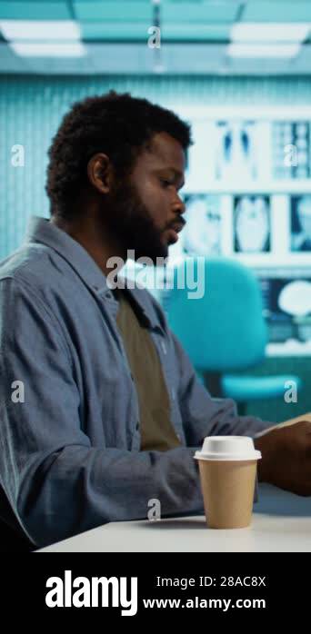 Vertical video Black male patient bringing x ray test results to medic ...