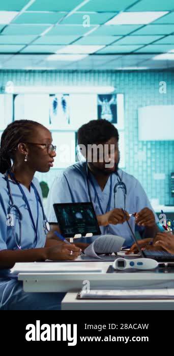 Vertical video African American doctor discussing with her nurses ...