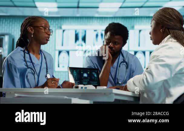 Group of healthcare specialists in scrubs analyzing results with doctor ...