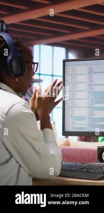 Vertical video Excited programmer wearing headphones testing code on PC ...