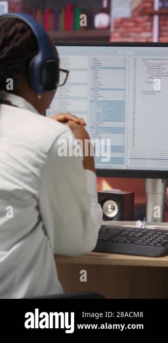 Vertical video Cheerful software developer at computer waiting for code ...