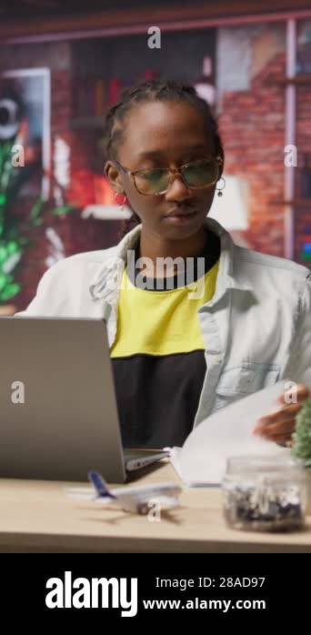 Vertical video Remote worker at home office desk looking over folder ...