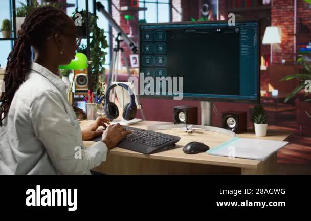 Woman seated at desk using AI LLM chatbot software in modern urban home office. Person ...