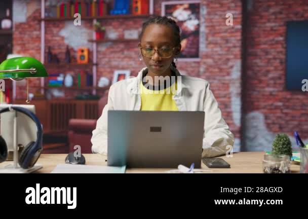 Portrait of happy teleworker using laptop in home office to write ...