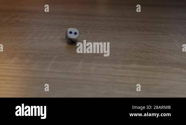 spinning dice on the wooden table Stock Video Footage - Alamy