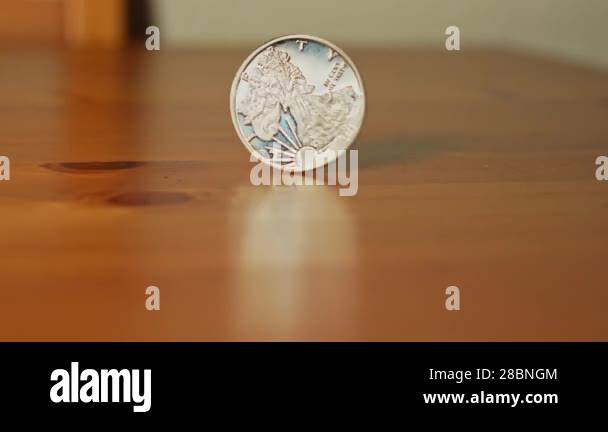 American Silver Dollar Coin Spinning on a Table in Slow Motion Stock ...