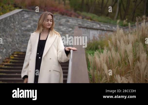 A stylish woman elegantly poses amidst a beautiful natural setting ...