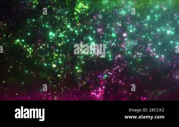 Multi colored particles flying on a dark black background in an ...