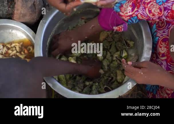 Young African girls take out clams from seashells on the street near ...