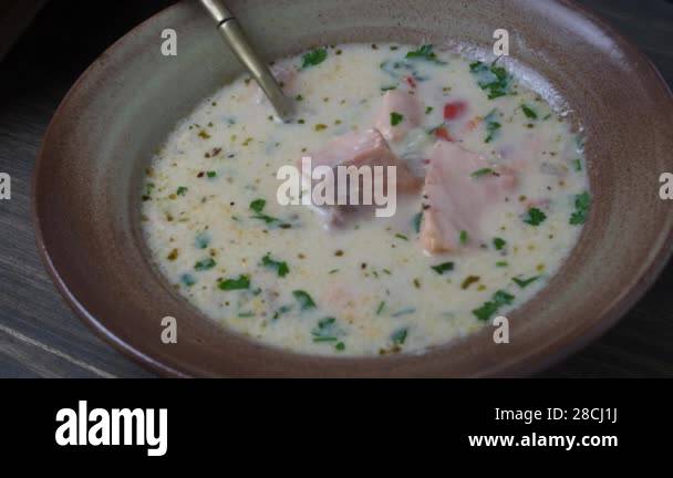 Salmon fish soup with cream, potato, carrot, pepper and herbs in a bowl ...