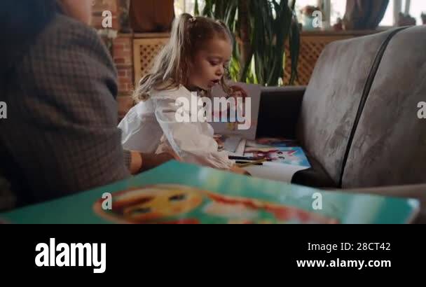 A young girl is happily spending her time coloring and exploring her ...