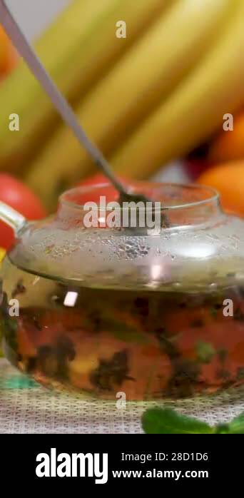 tea stir in a glass teapot close the lid on the table fruits croissant ...