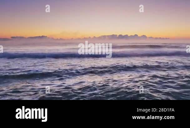 Sunrise over the sea horizon, foggy morning and ripples water to the ...