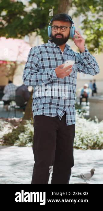 Happy overjoyed Indian bearded man dancing in wireless headphones ...