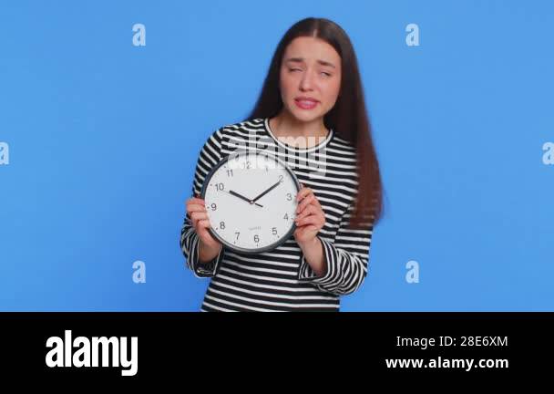 Caucasian woman with anxiety checking time on clock, running late to ...