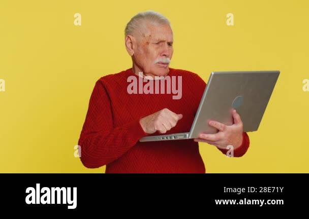 Displeased senior man use laptop notebook typing browsing working ...