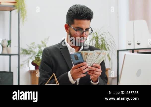 Happy rich Indian bearded businessman counting money dollar cash, use ...