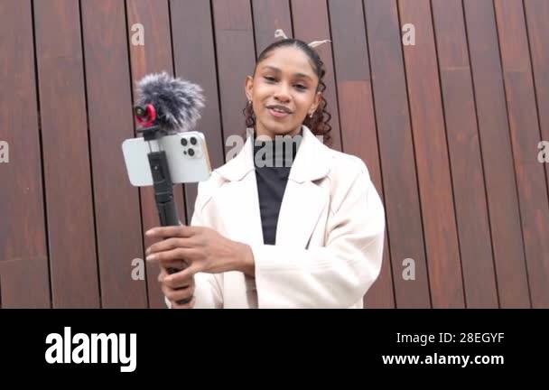 Content creator recording a vlog in slow motion using a smartphone and ...