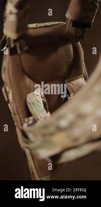 A detailed close-up of a tactical vest made with camouflage fabric and ...