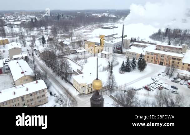 A snow covered urban landscape featuring a tall spire with a golden ...