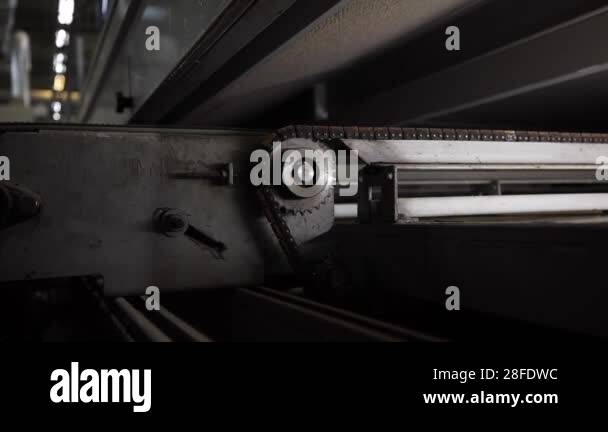 Detailed view of a metal sprocket connected to a chain mechanism ...