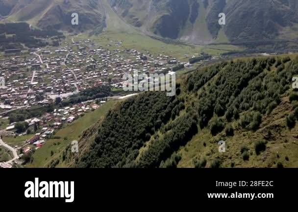 A small town with a grid like layout sits in a valley, bordered by a ...