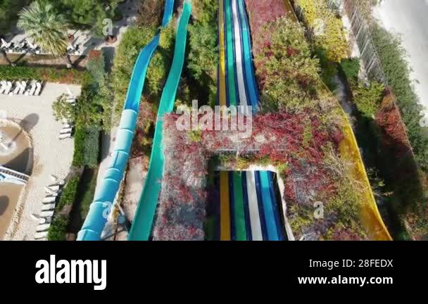 A dynamic water park features twisting blue and yellow slides ...