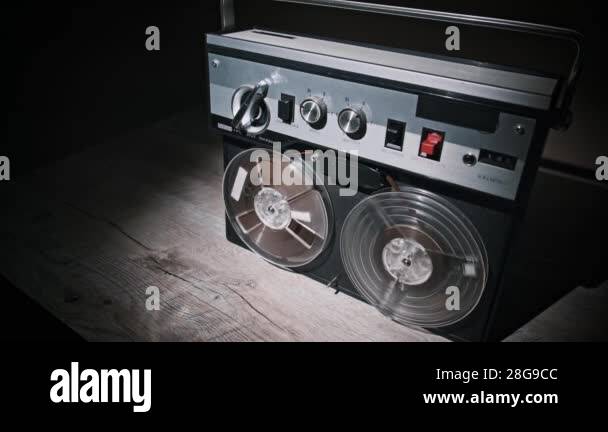 Retro reel to reel tape recorder plays audio, with tape reels turning ...