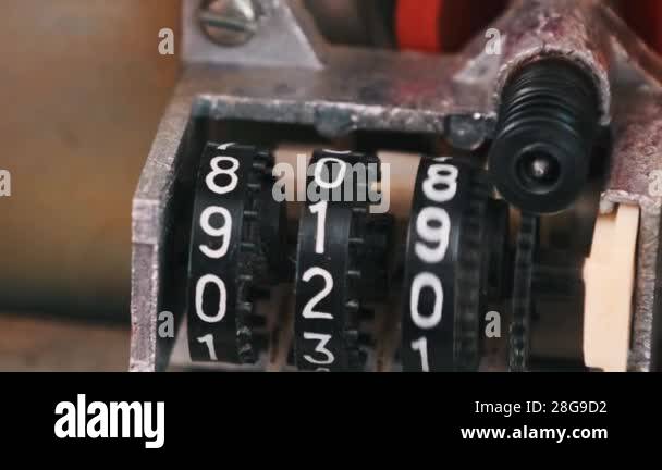 A macro view of a vintage counter with its black dials precisely moving ...