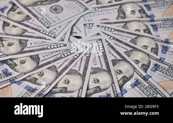 A pile of crisp 100 US dollar bills is arranged in a fanning pattern on ...