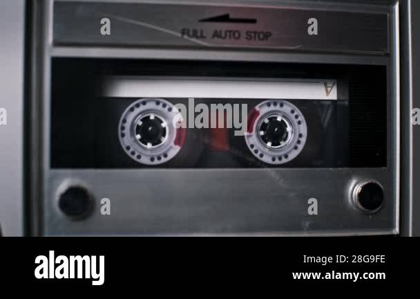 Close-up view of various colorful cassette tapes playing continuously ...