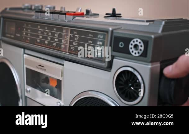 Hand adjusts the tuning dial on a vintage deck, selecting different ...