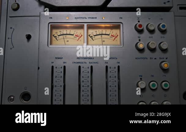 Close view of a classic tape decks front panel with lit VU meters and ...