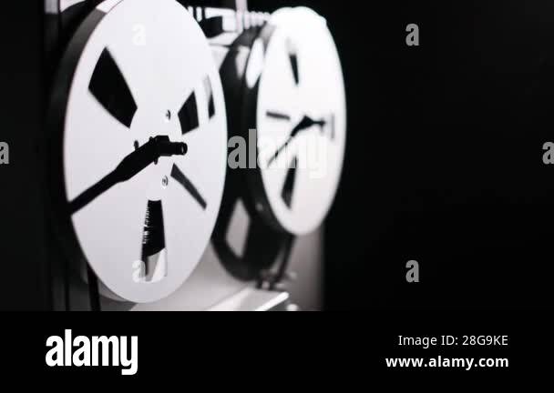 Detailed close up of an open reel tape recorder spools spinning against ...