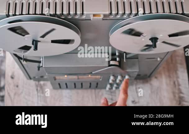 A top-down shot showcases a person starting and stopping a vintage reel ...