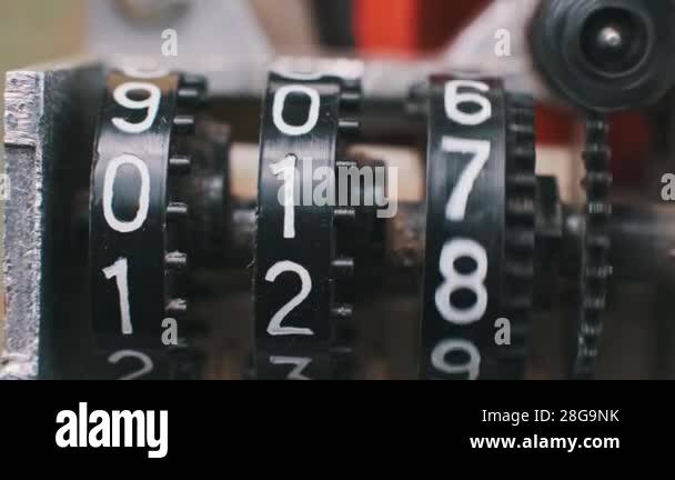 A macro close-up of a retro mechanical counter, focused on the rotating number wheels ...