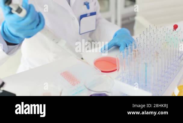 Lab technician uses advanced equipment to distribute liquid ...