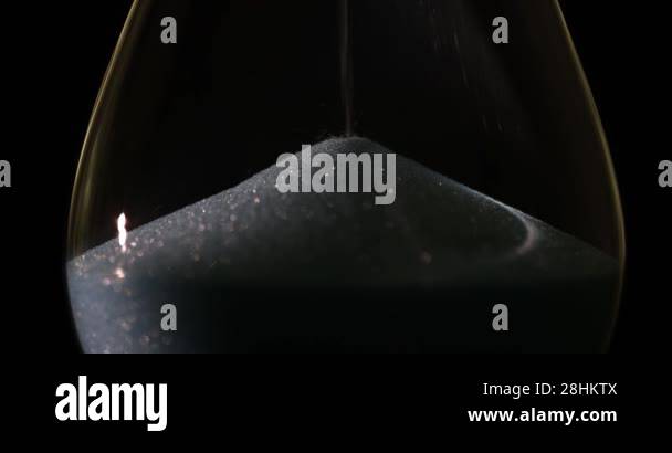 Grains of sand fall slowly creating pile in sand-glass chamber. Sand ...