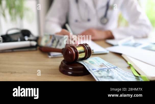 A medical professional examining documents with a gavel and stacks of ...